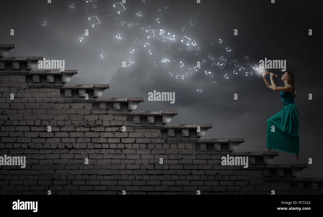 Young pretty woman in green long gress playing fife Stock Photo - Alamy