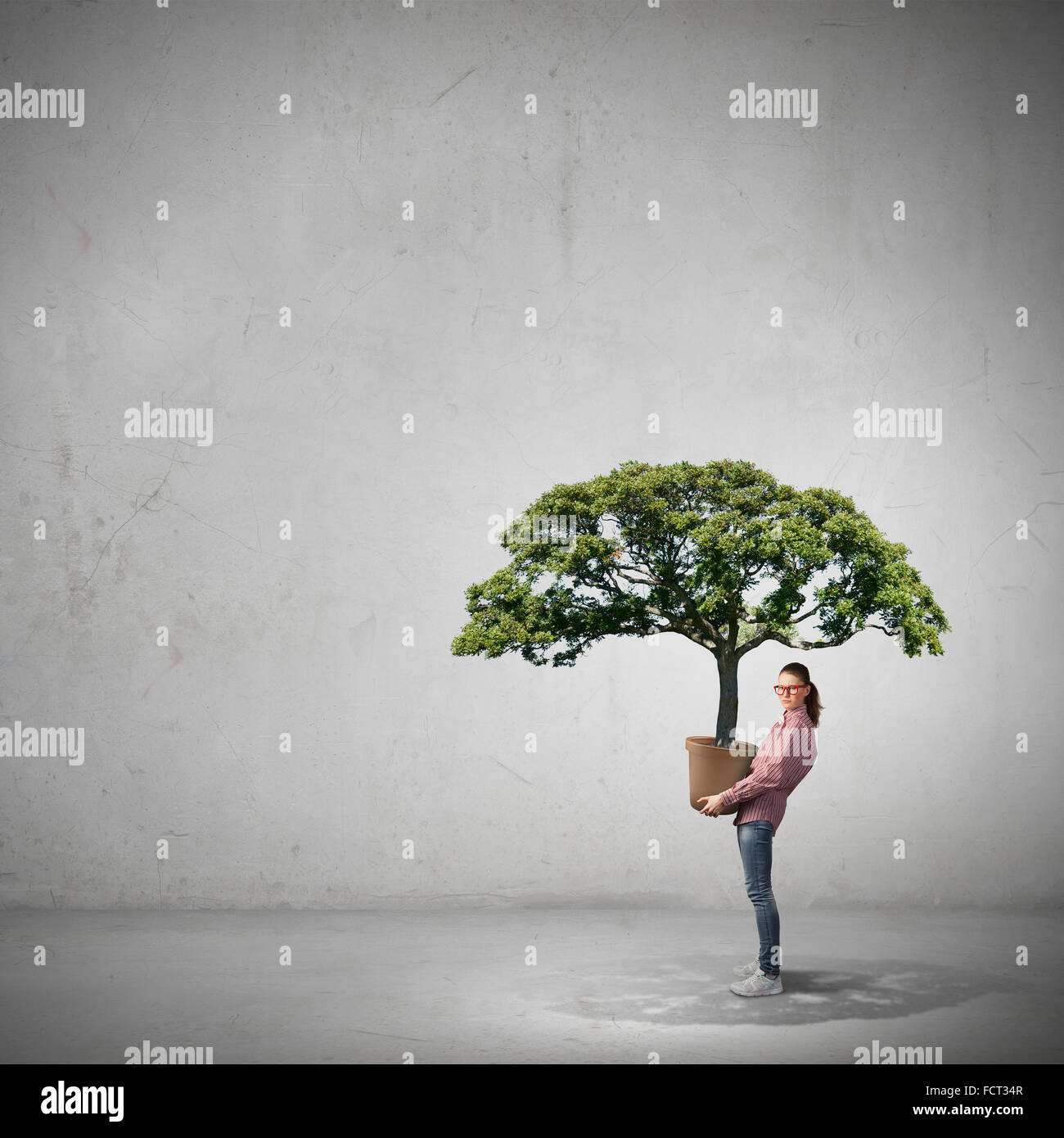 Young girl student carrying green tree in pot Stock Photo - Alamy