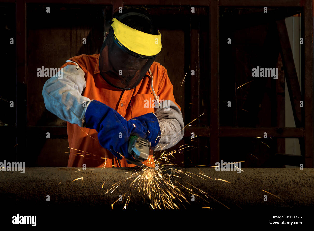 Industrial worker cutting and welding metal with many sharp sparks ...