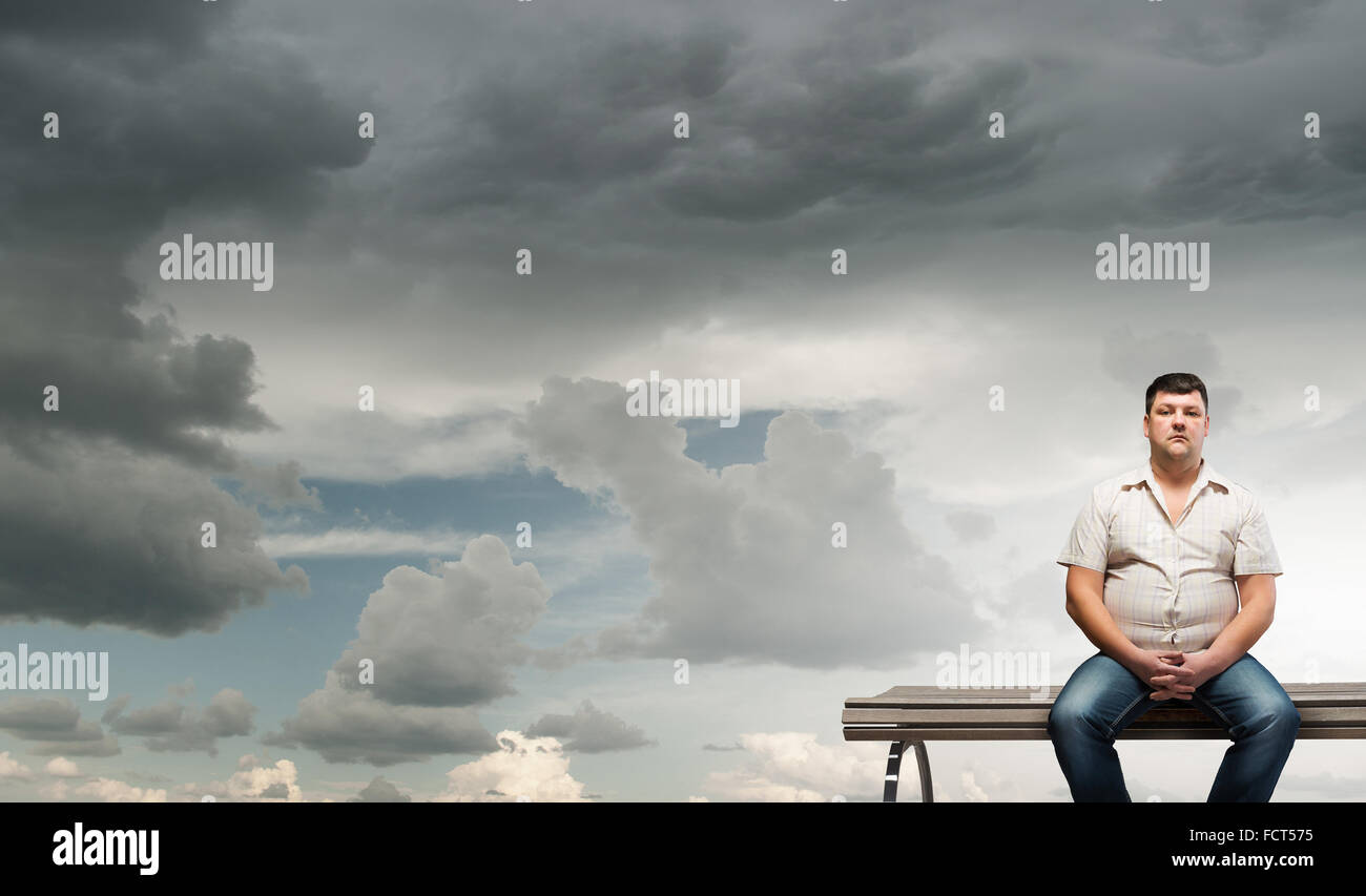 Fat man sitting on bench and looking in camera Stock Photo - Alamy