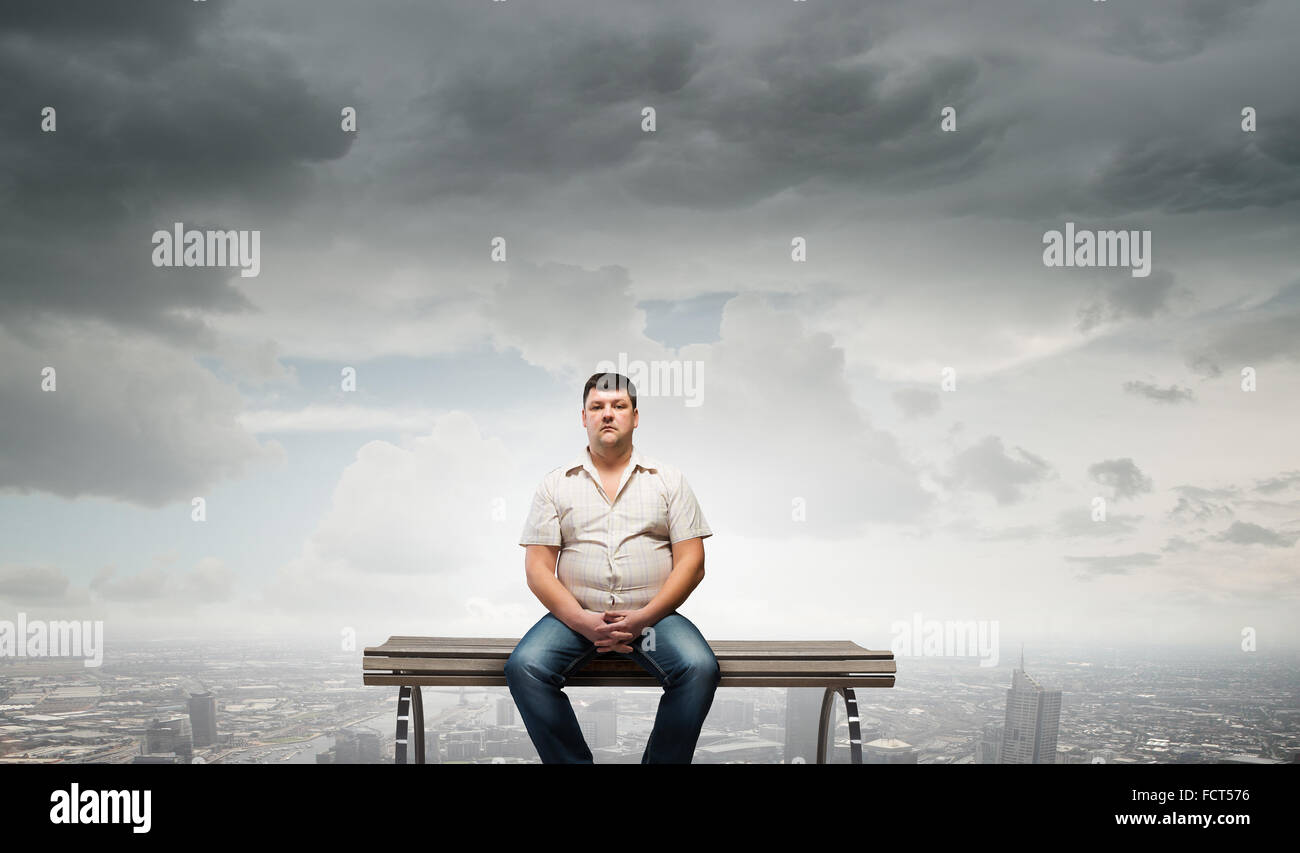 Fat man sitting on bench and looking in camera Stock Photo - Alamy