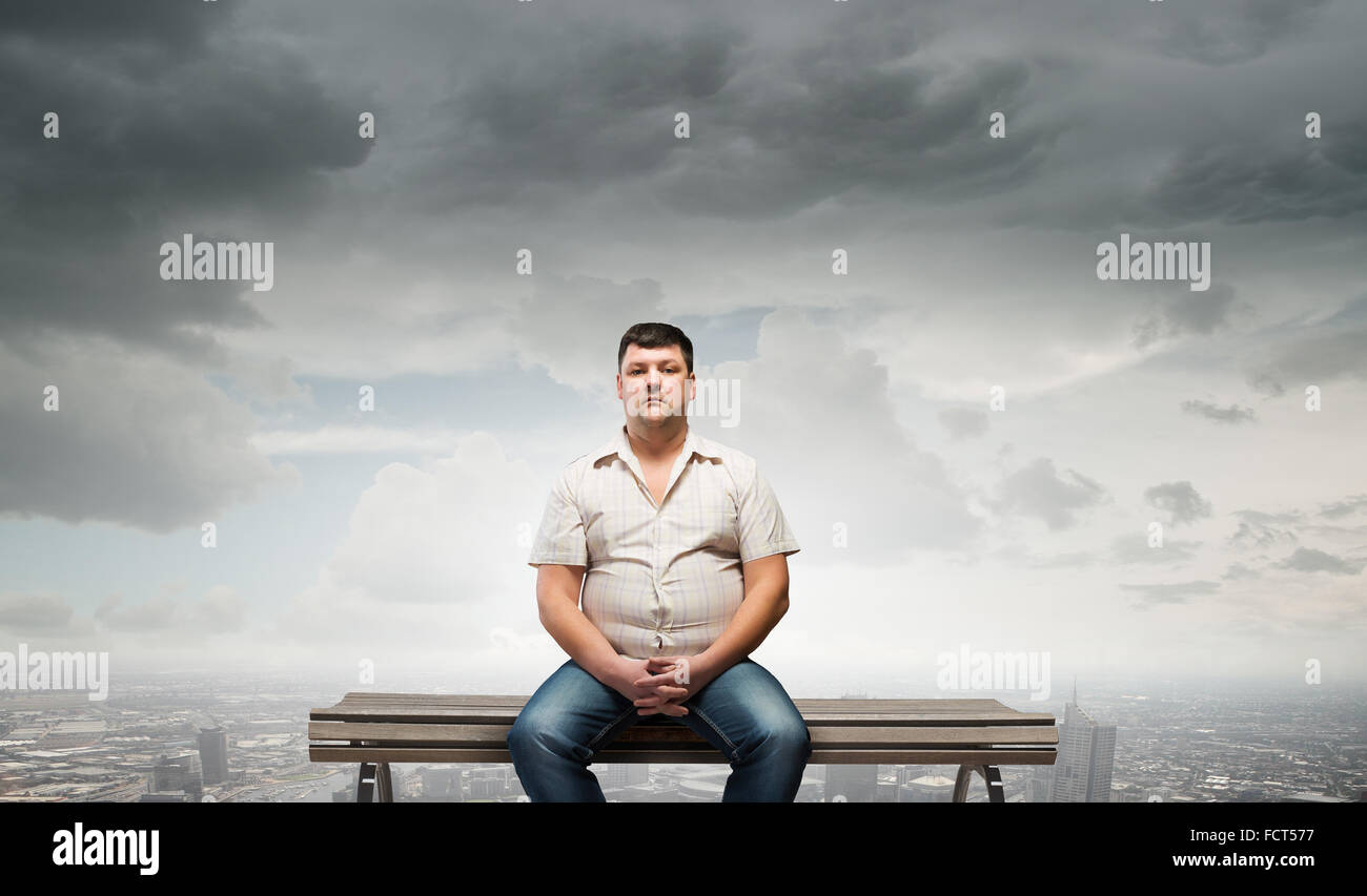 Fat man sitting on bench and looking in camera Stock Photo - Alamy
