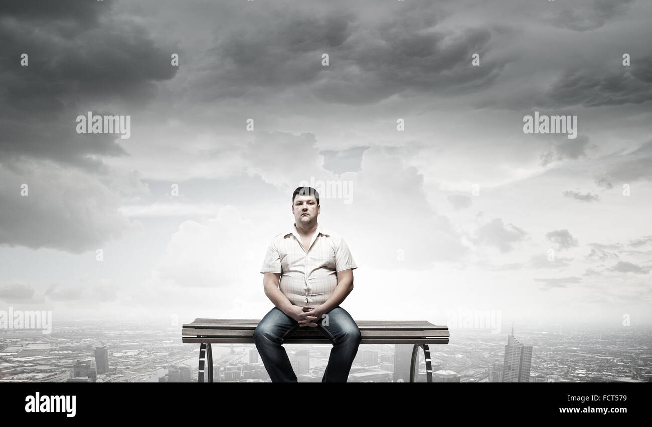 Fat man sitting on bench and looking in camera Stock Photo - Alamy