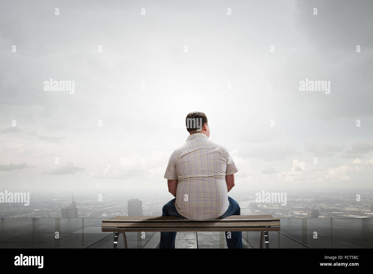 Fat man sitting on bench with his back and looking away Stock Photo - Alamy