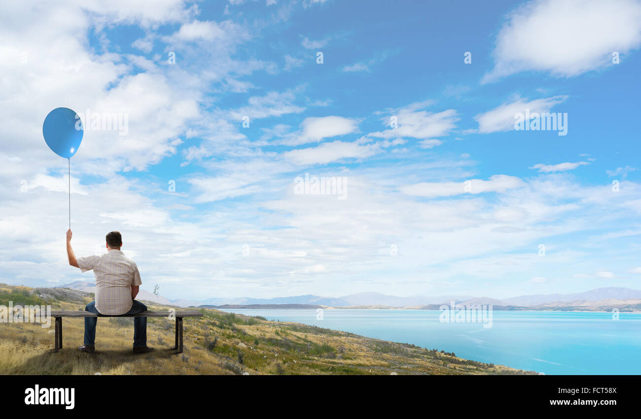 Fat man sitting on bench with his back with balloon in hand Stock Photo ...