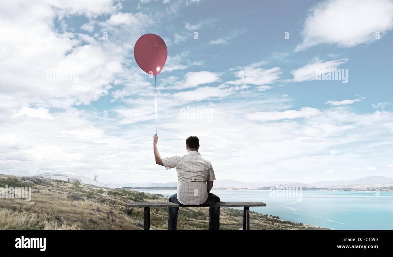 Fat man sitting on bench with his back with balloon in hand Stock Photo ...