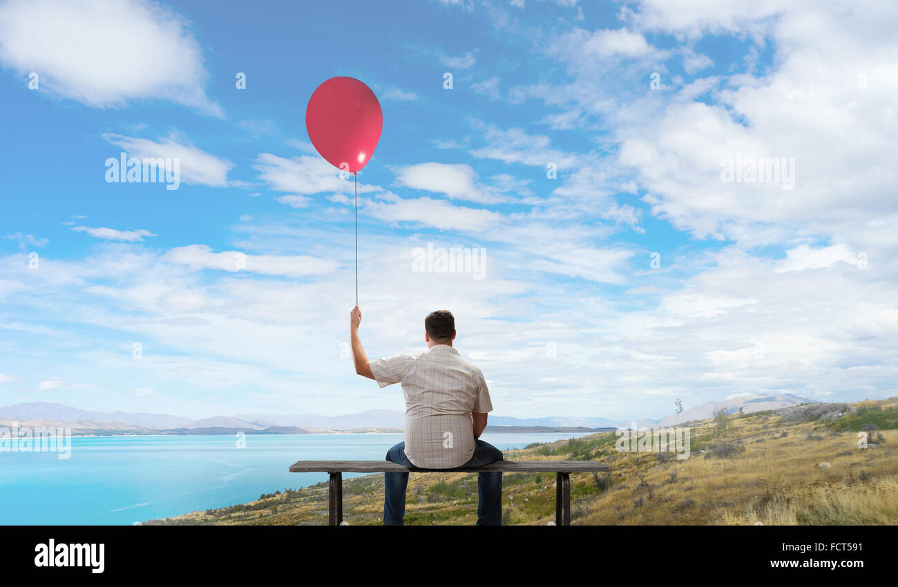 Fat man sitting on bench with his back with balloon in hand Stock Photo ...
