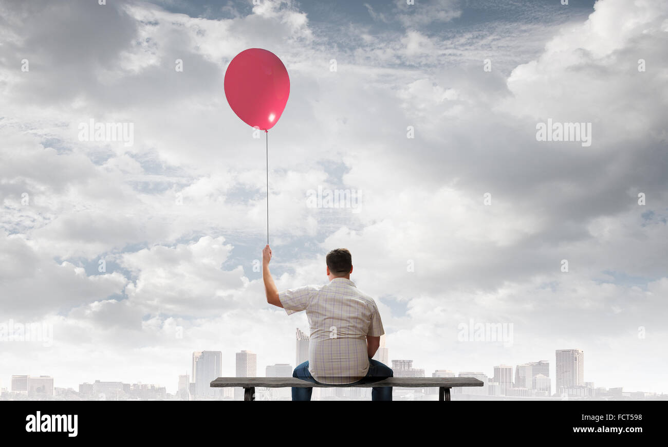 Fat man sitting on bench with his back with balloon in hand Stock Photo ...