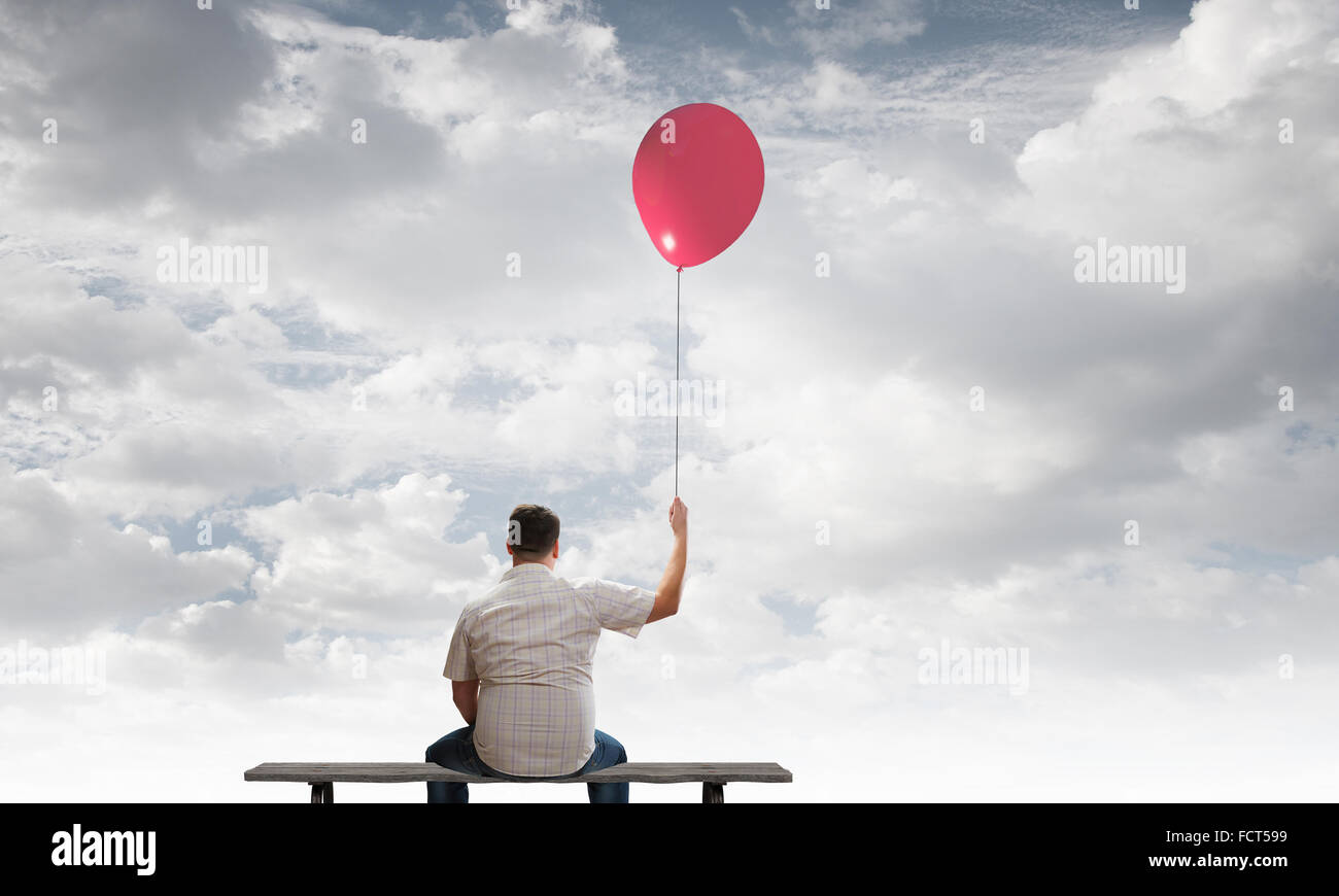 Fat man sitting on bench with his back with balloon in hand Stock Photo ...