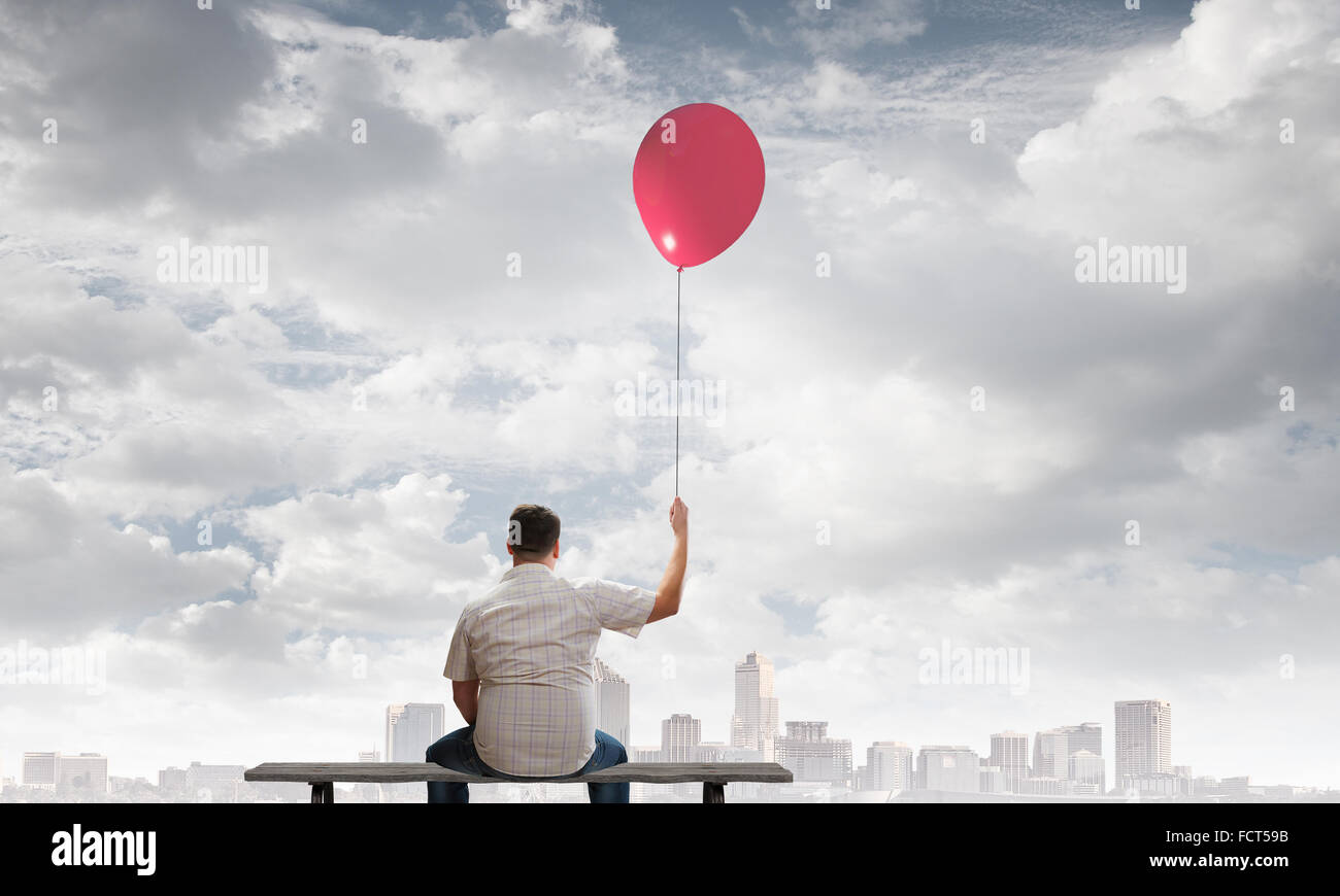 Fat man sitting on bench with his back with balloon in hand Stock Photo ...