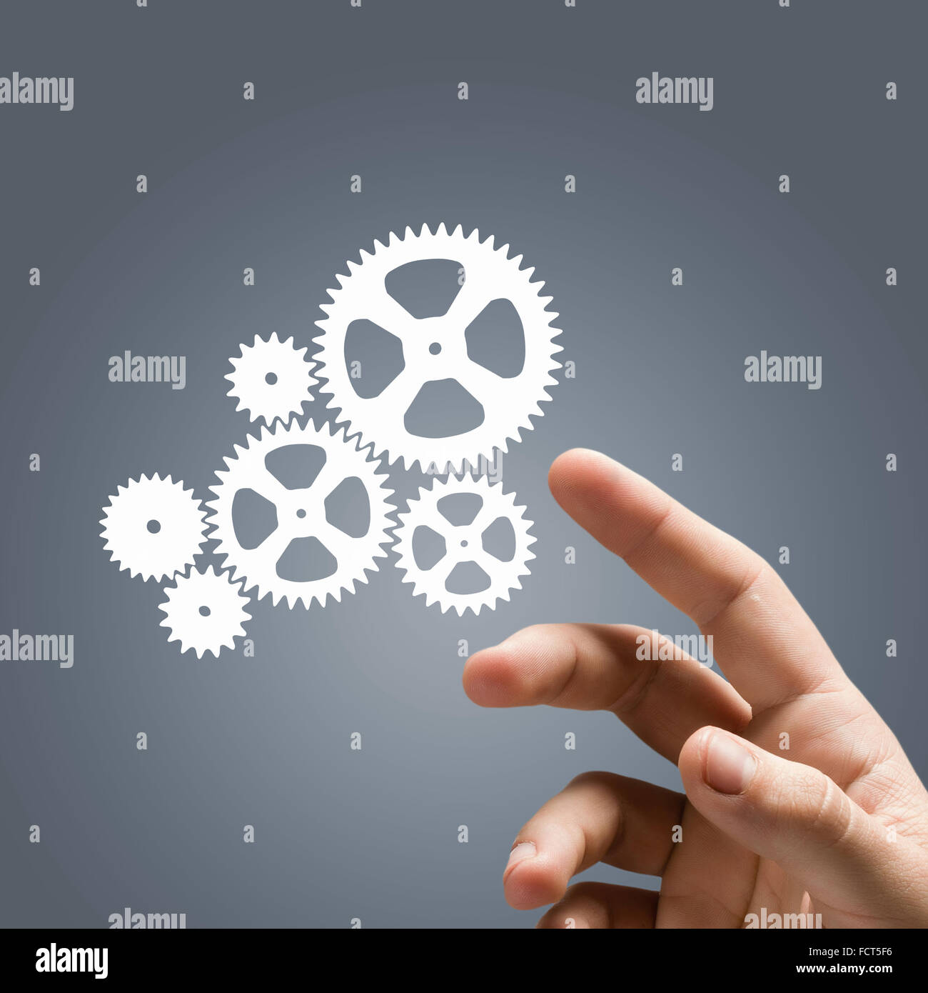 Close up of hand and gears mechanism on gray background Stock Photo - Alamy