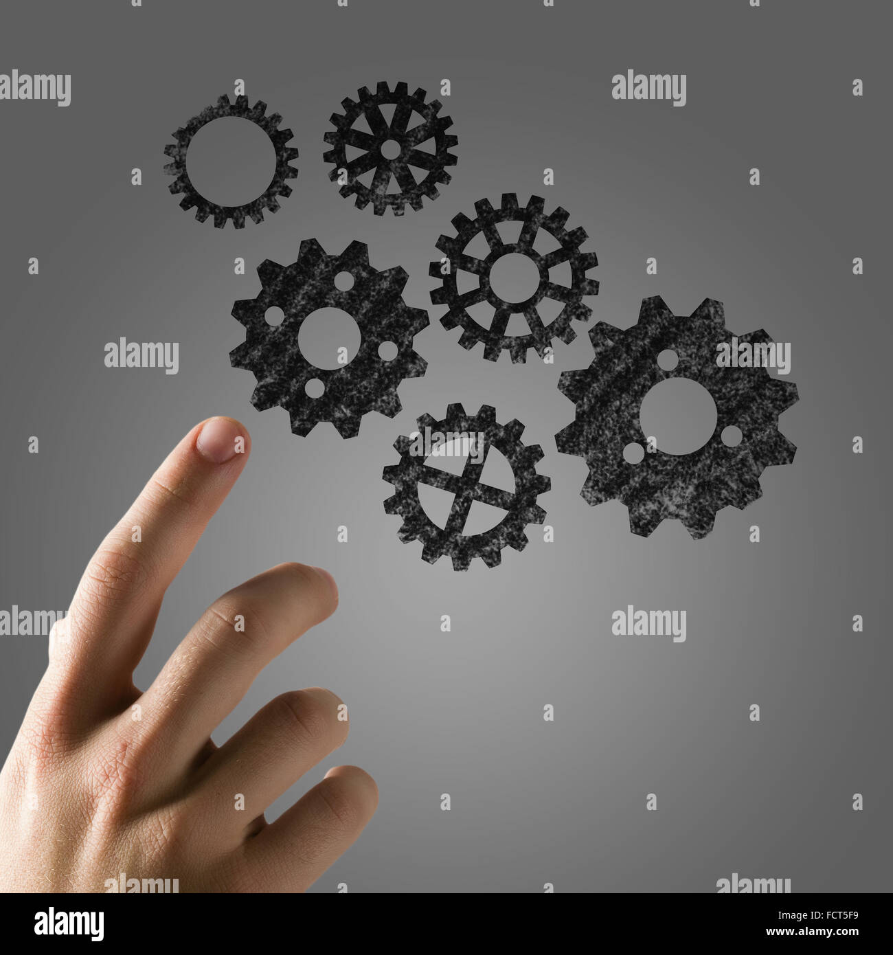 Close up of hand and gears mechanism on gray background Stock Photo - Alamy