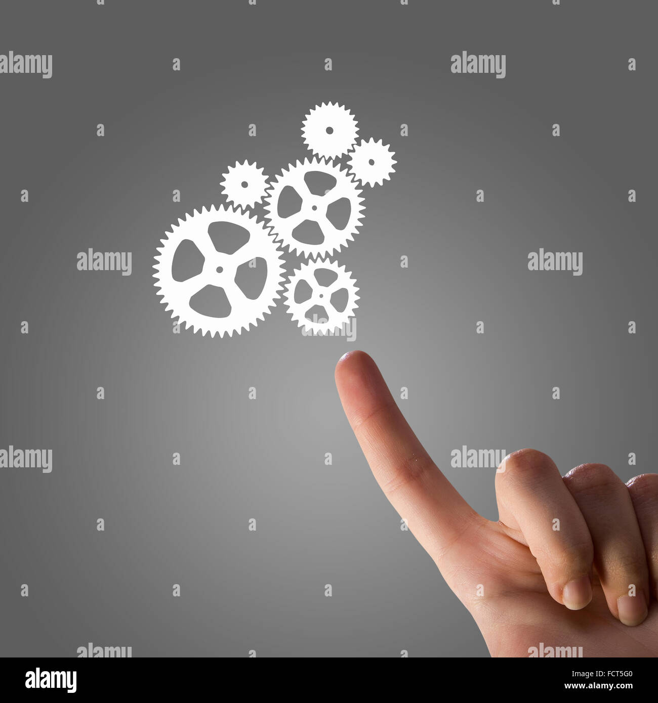Close up of hand and gears mechanism on gray background Stock Photo - Alamy