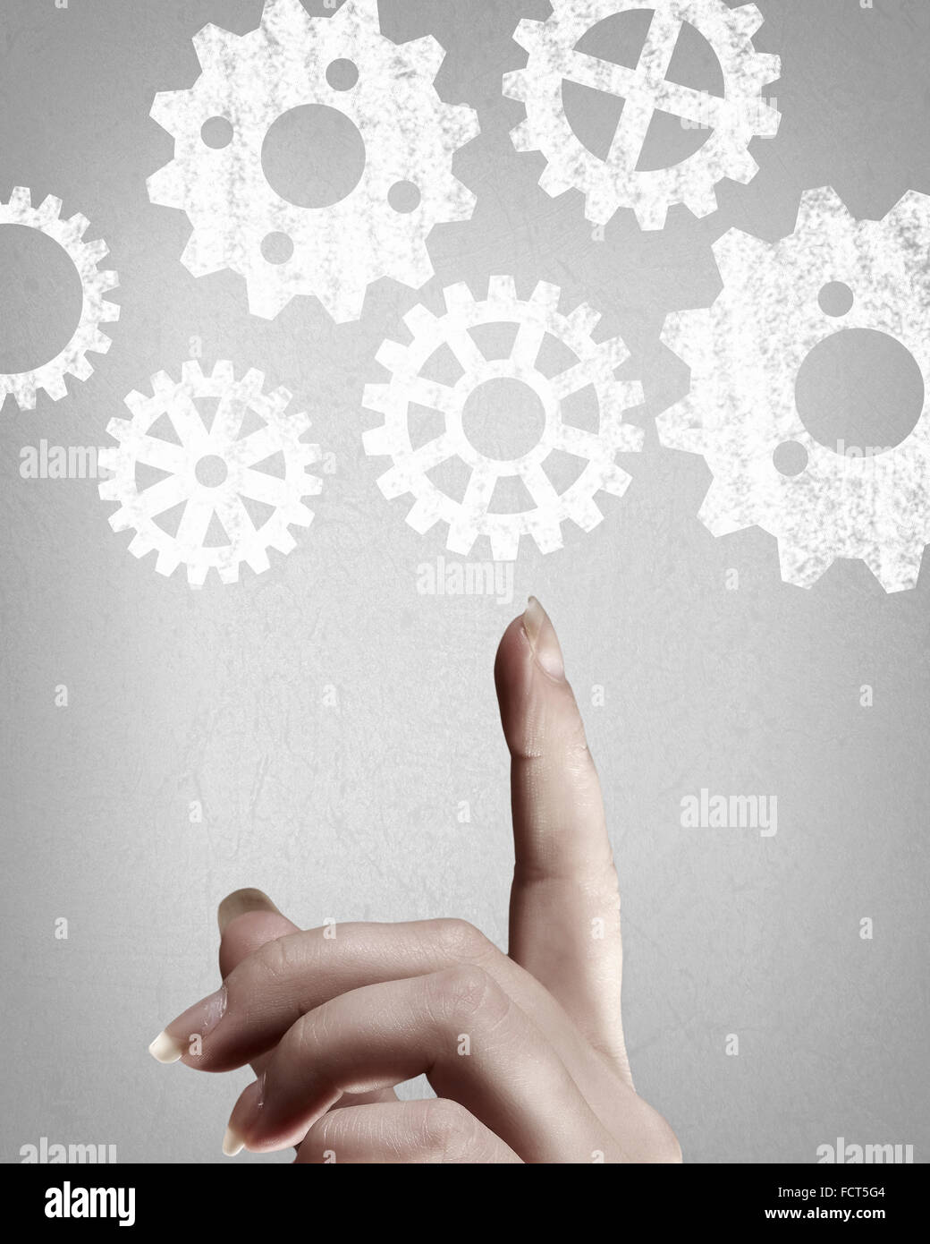 Close up of hand and gears mechanism on gray background Stock Photo - Alamy