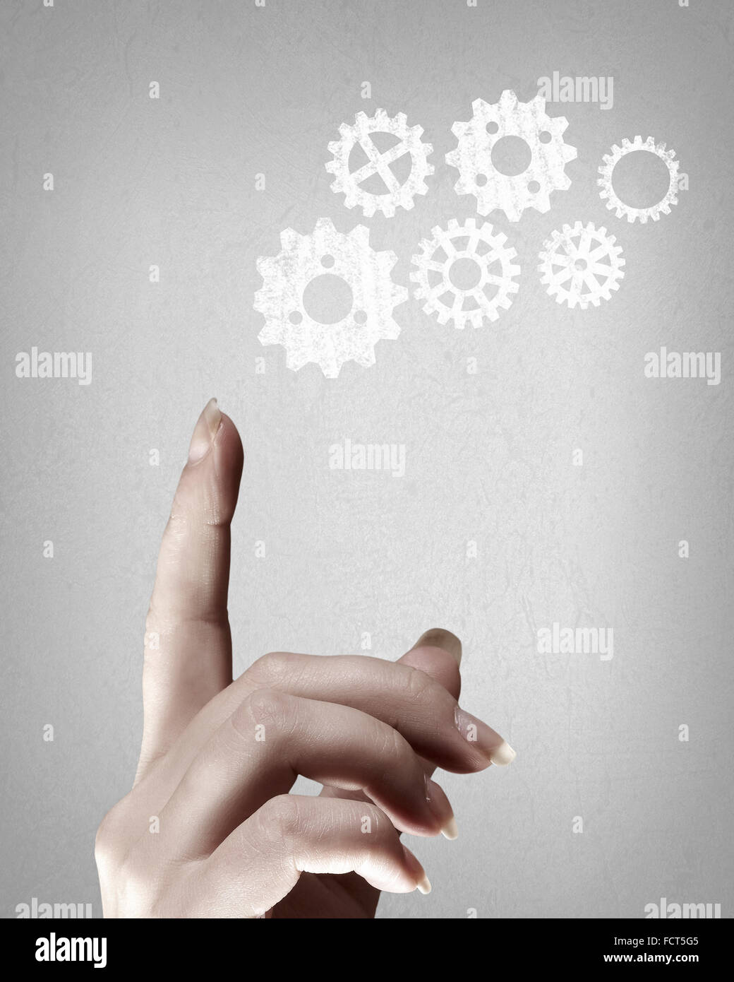 Close up of hand and gears mechanism on gray background Stock Photo - Alamy