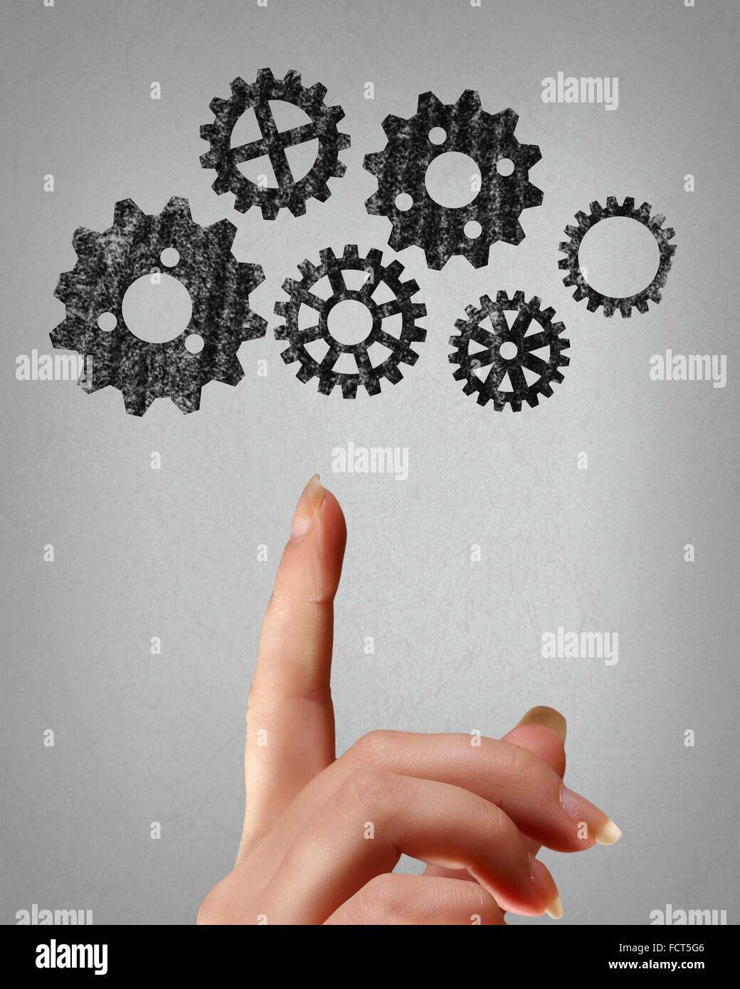 Close up of hand and gears mechanism on gray background Stock Photo - Alamy