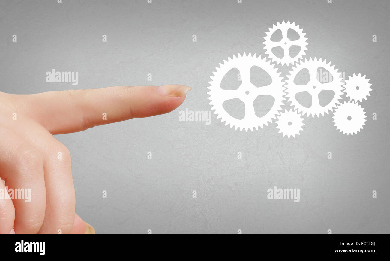 Close up of hand and gears mechanism on gray background Stock Photo - Alamy