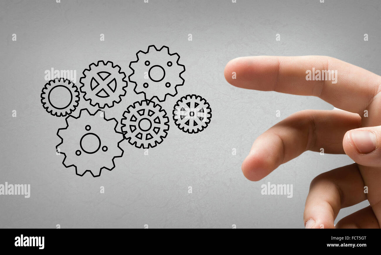 Close up of hand and gears mechanism on gray background Stock Photo - Alamy