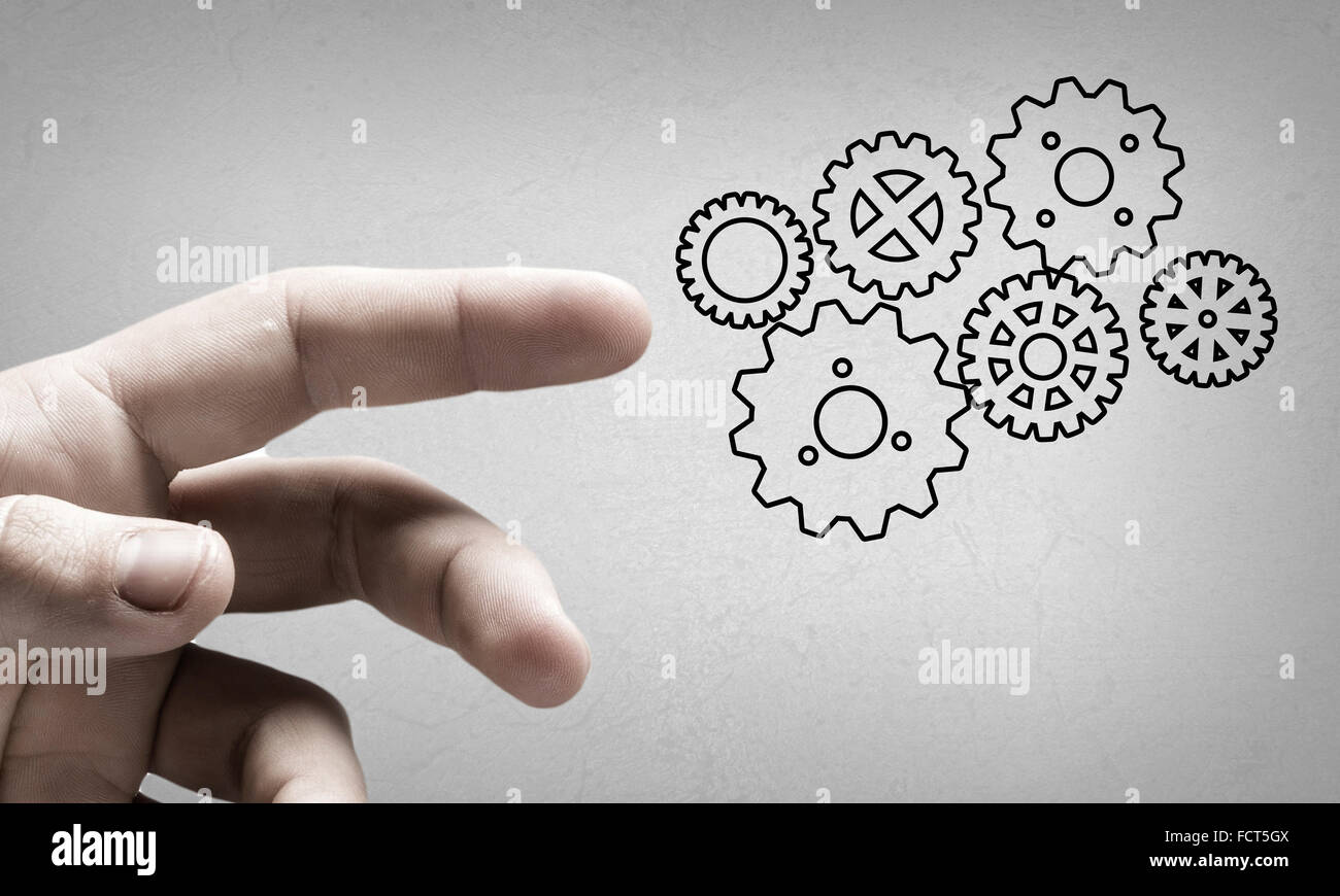 Close up of hand and gears mechanism on gray background Stock Photo - Alamy