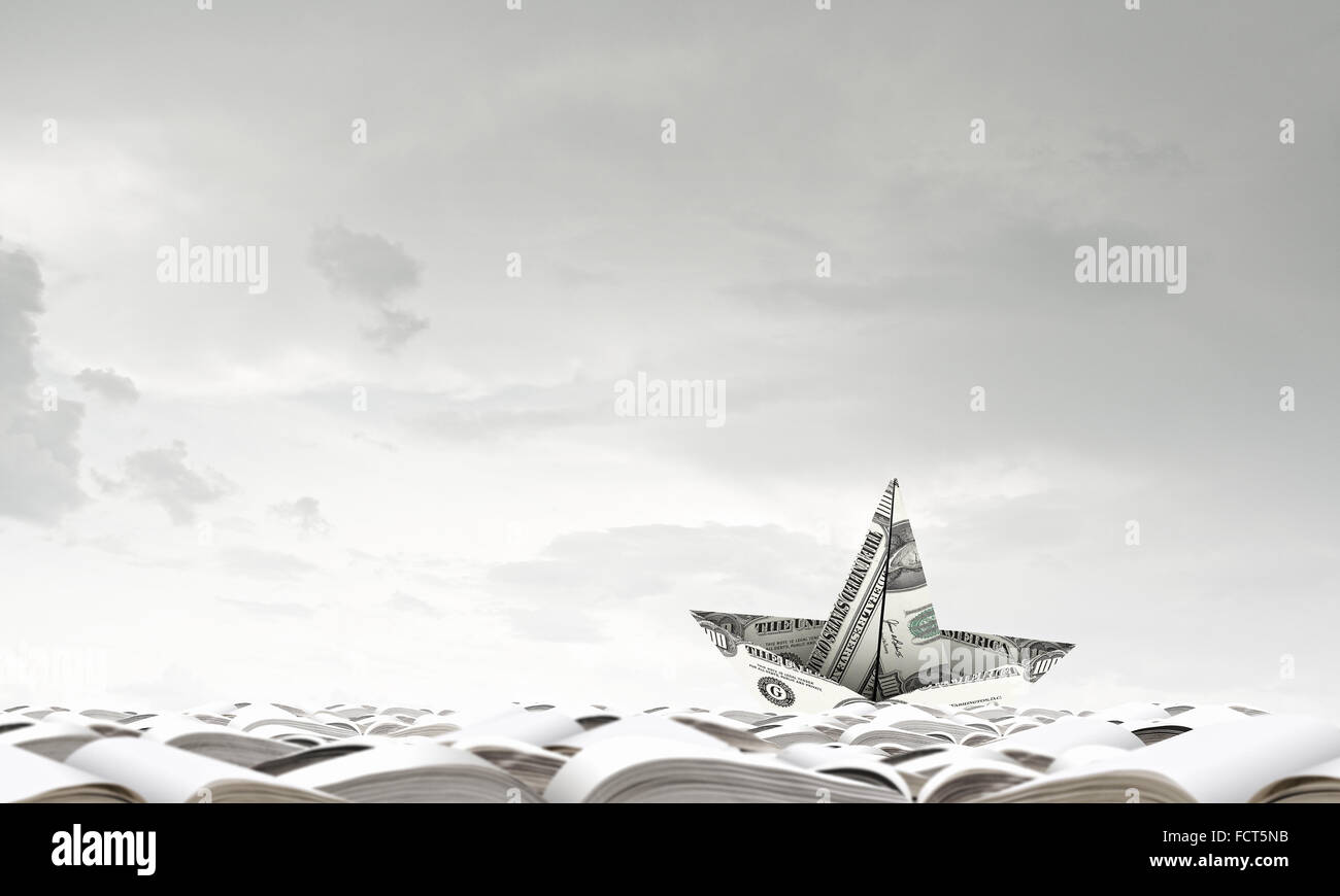 Ship made of dollar banknote floating on pile of books Stock Photo - Alamy