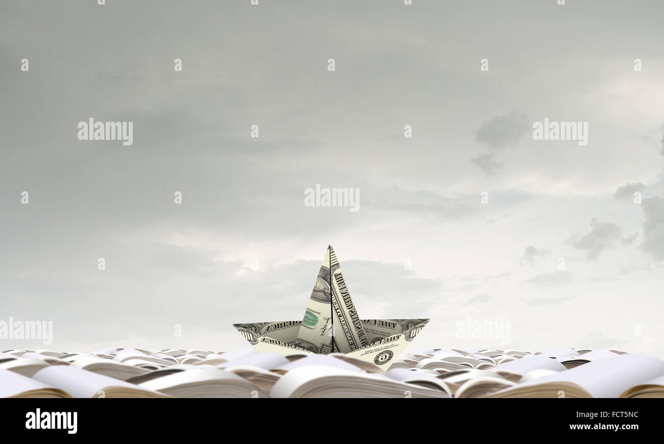 Ship made of dollar banknote floating on pile of books Stock Photo - Alamy