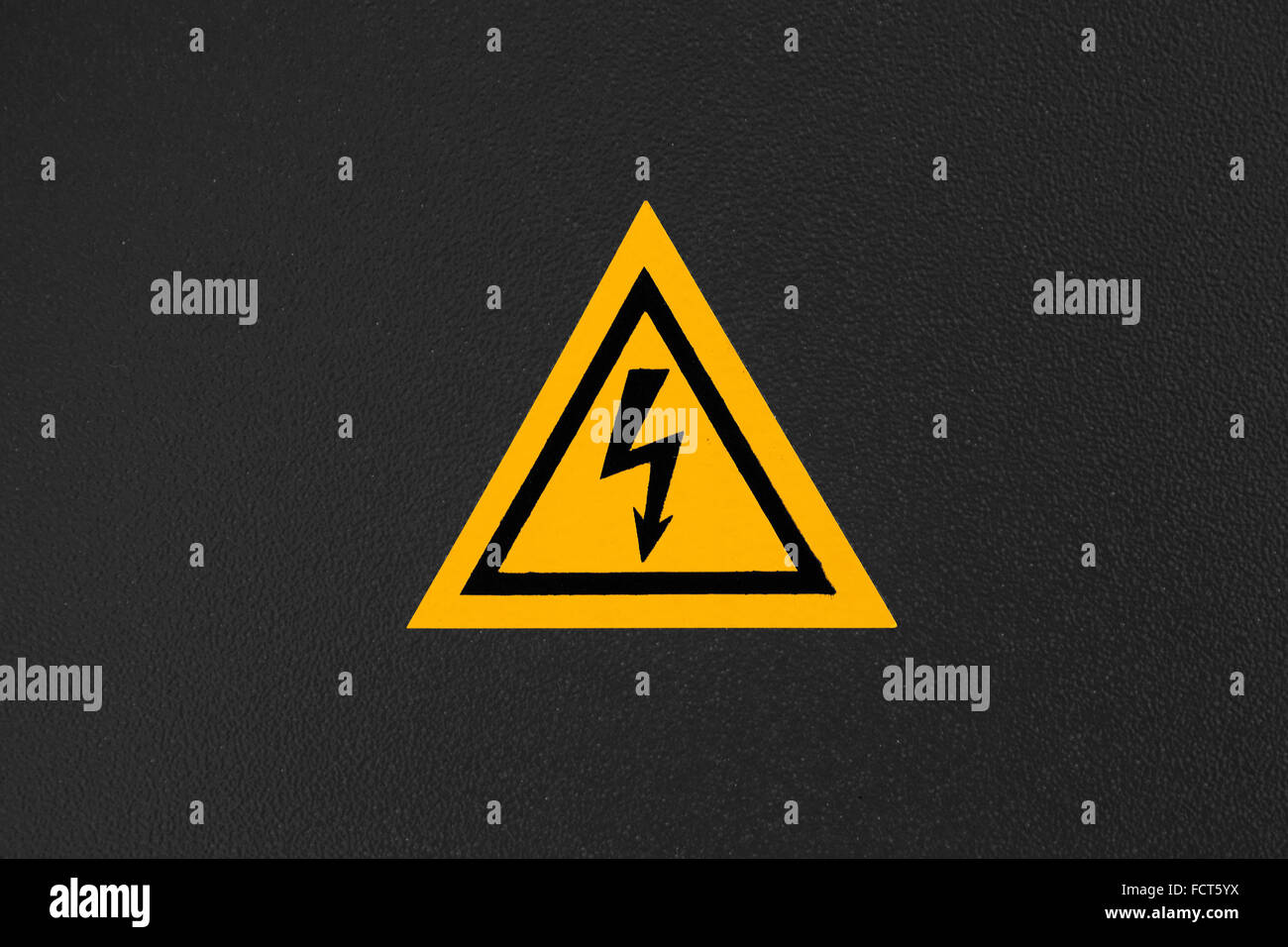 High voltage triangle warning sign mounted on black metal wall Stock ...