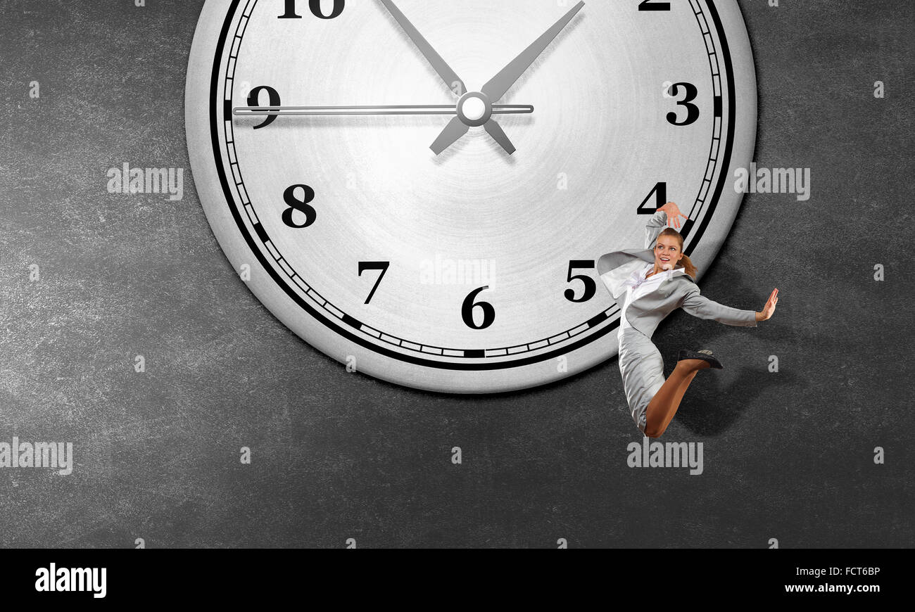 Concept of time with jumping businesswoman over big alarm clock Stock ...