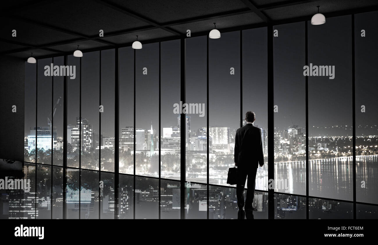 Businessman standing with back and looking in office window Stock Photo ...