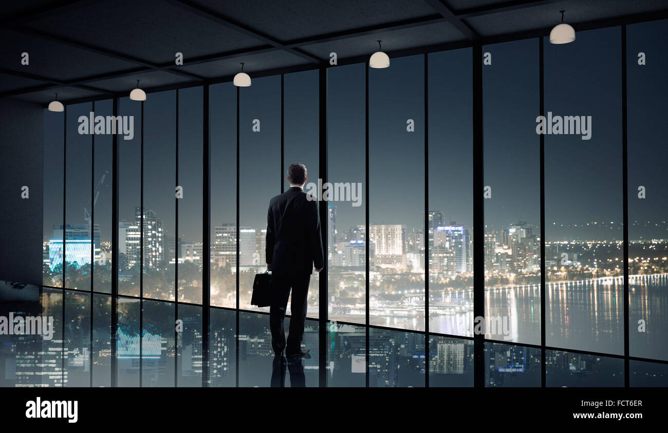 Businessman standing with back and looking in office window Stock Photo ...