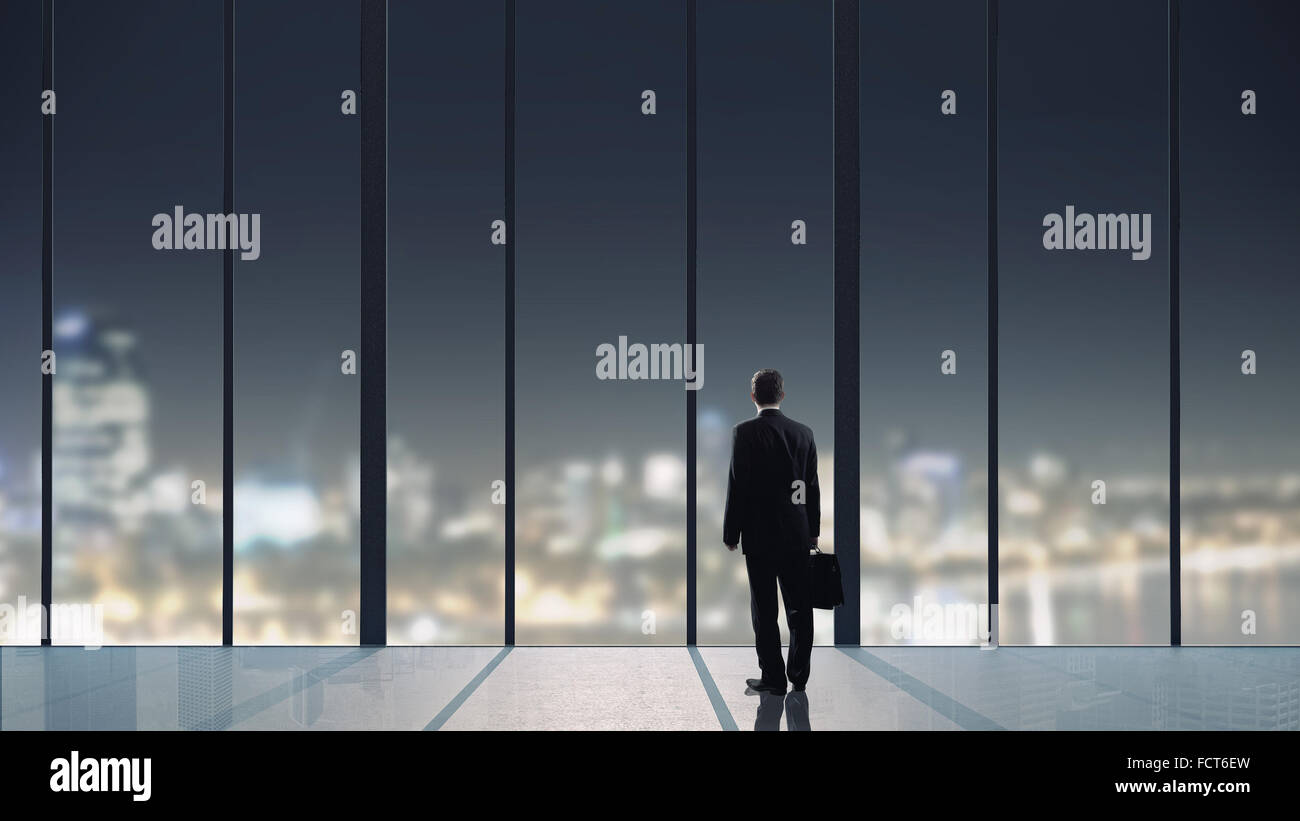 Businessman standing with back and looking in office window Stock Photo ...