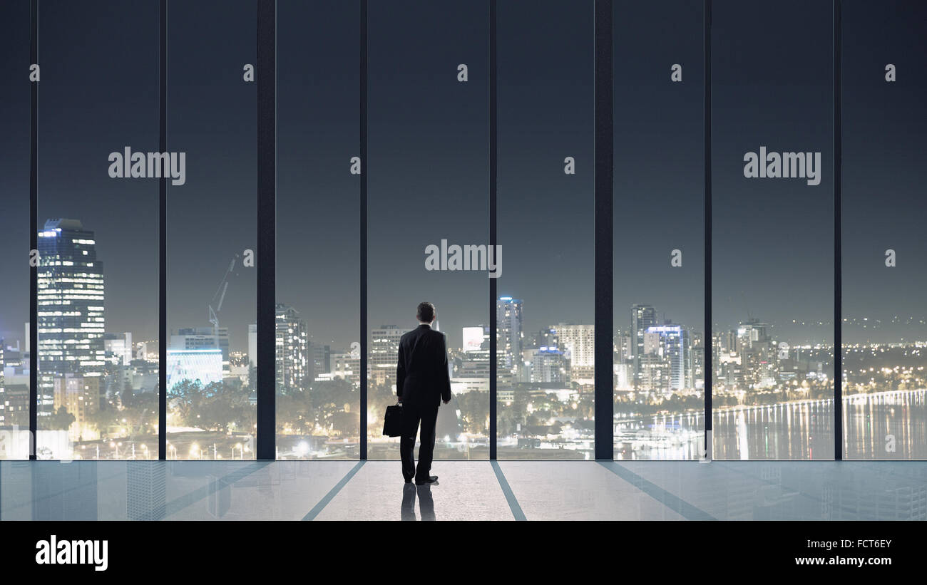 Businessman standing with back and looking in office window Stock Photo ...