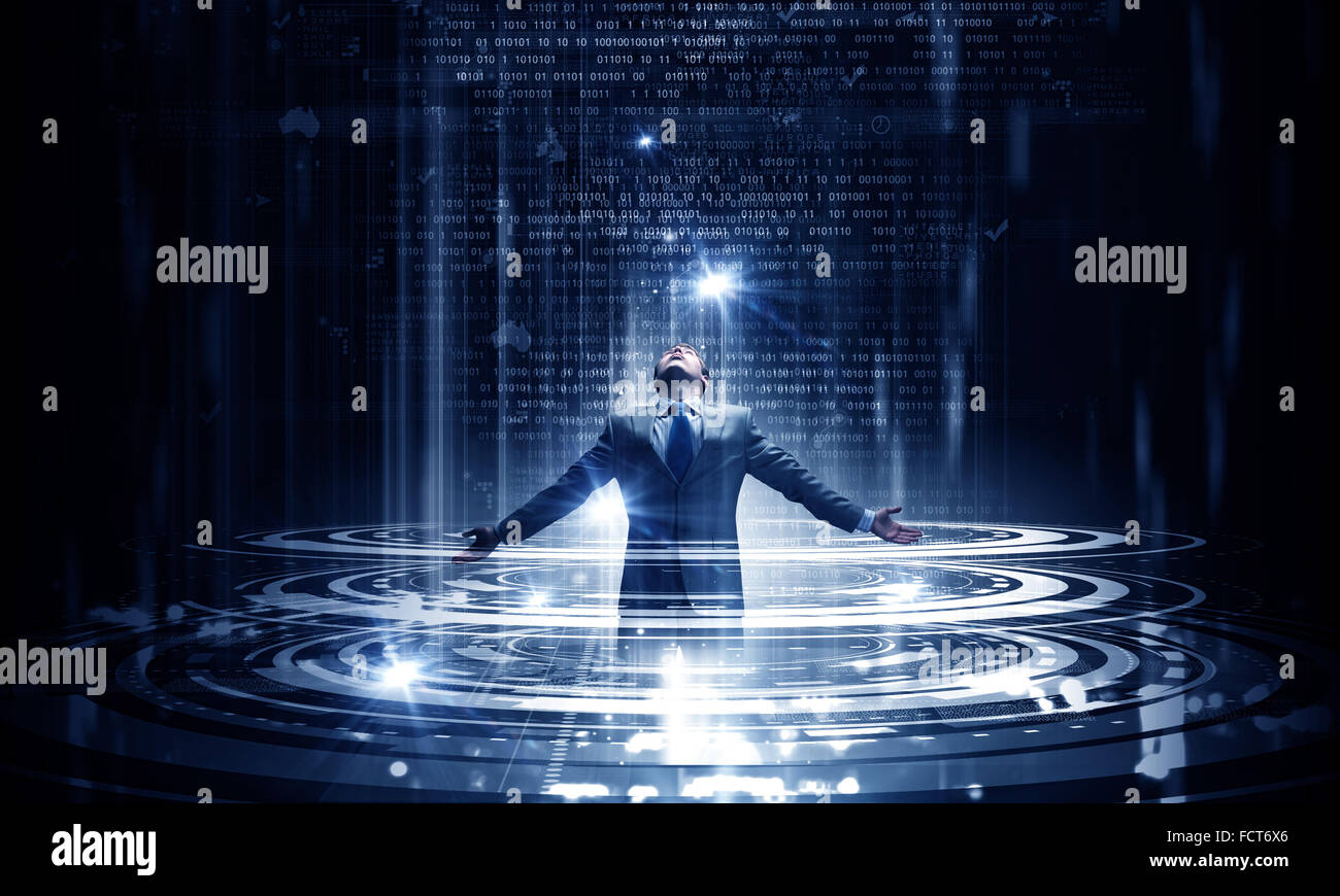 Businessman with hands spread apart standing in light coming from above ...