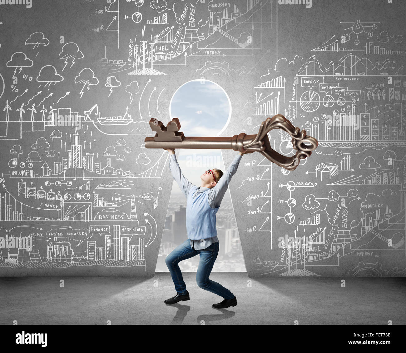 Young man in casual lifting big key above head Stock Photo - Alamy