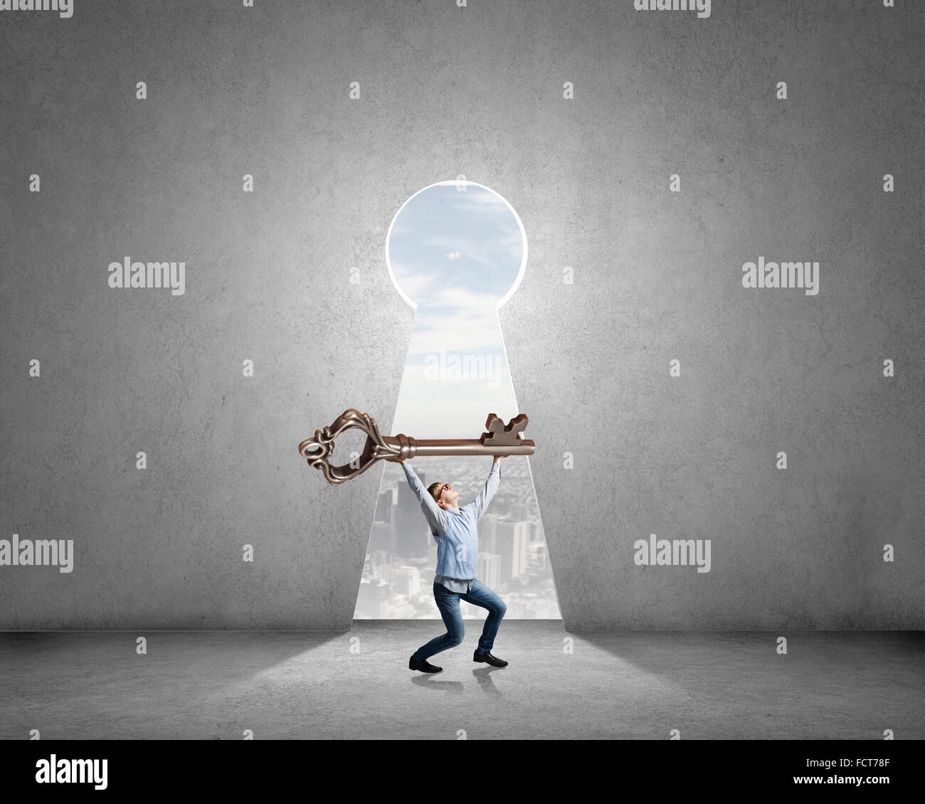Young man in casual lifting big key above head Stock Photo - Alamy