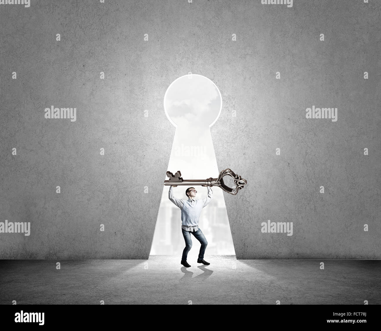 Young man in casual lifting big key above head Stock Photo - Alamy