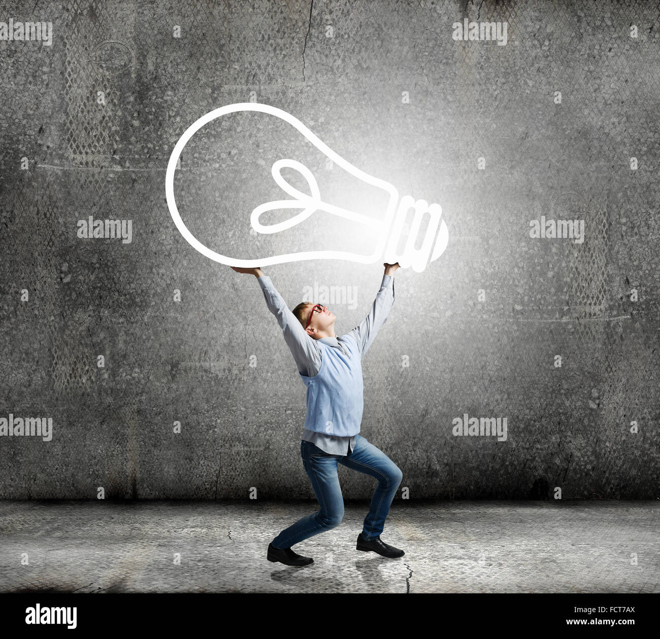 Young man lifting light bulb above head Stock Photo - Alamy