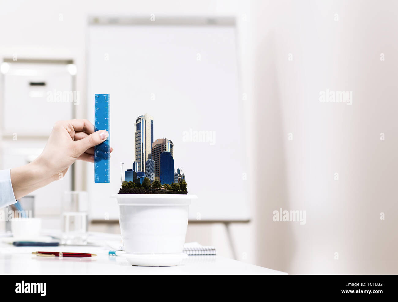 Close up of male hand measuring with ruler model of city Stock Photo ...
