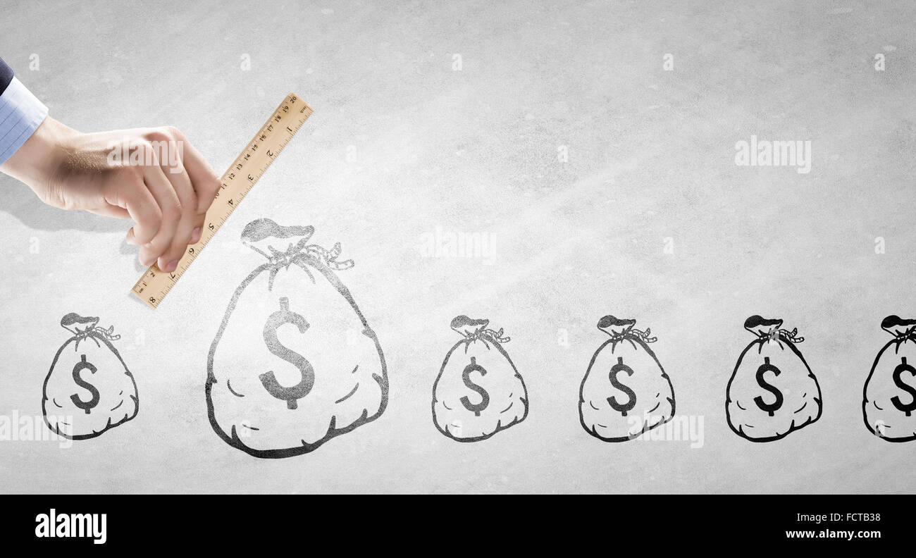 Close up of human hand measuring money bag with ruler Stock Photo - Alamy