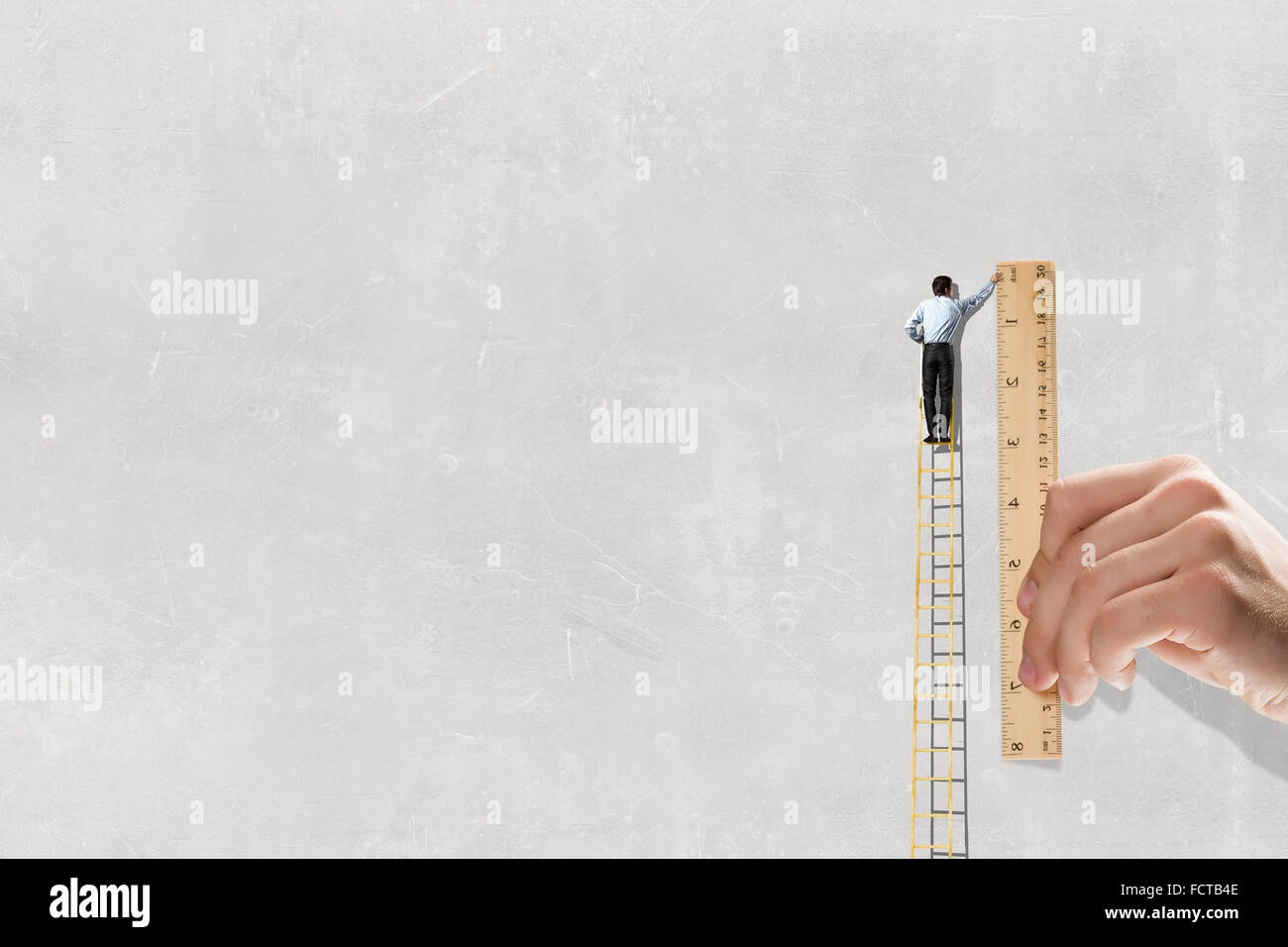 Young businessman standing on ladder and measured with ruler Stock ...