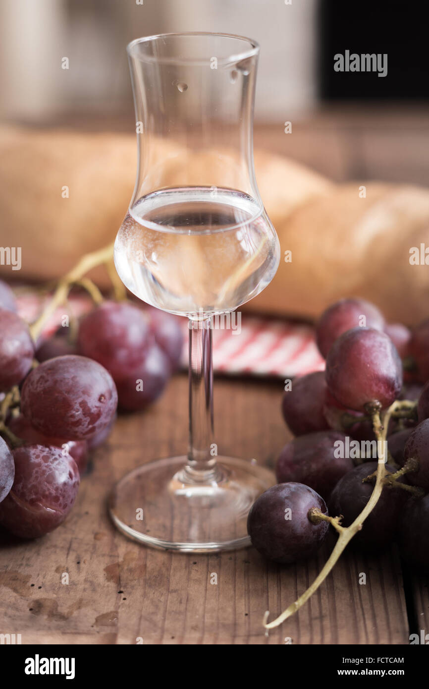 italien Grappa with Grape and Bread on wooden Table Stock Photo - Alamy