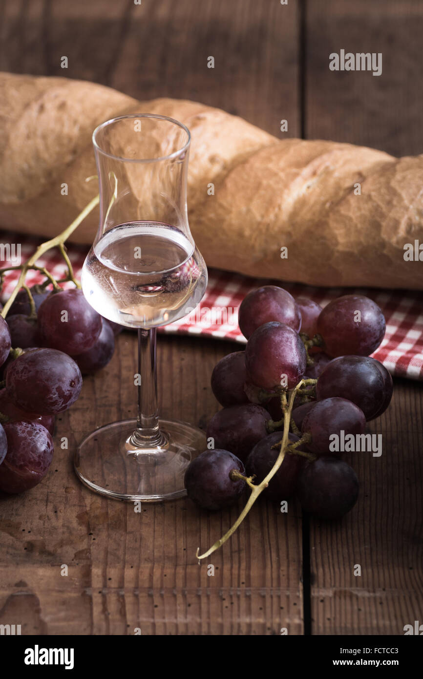 italien Grappa with Grape and Bread on wooden Table Stock Photo - Alamy