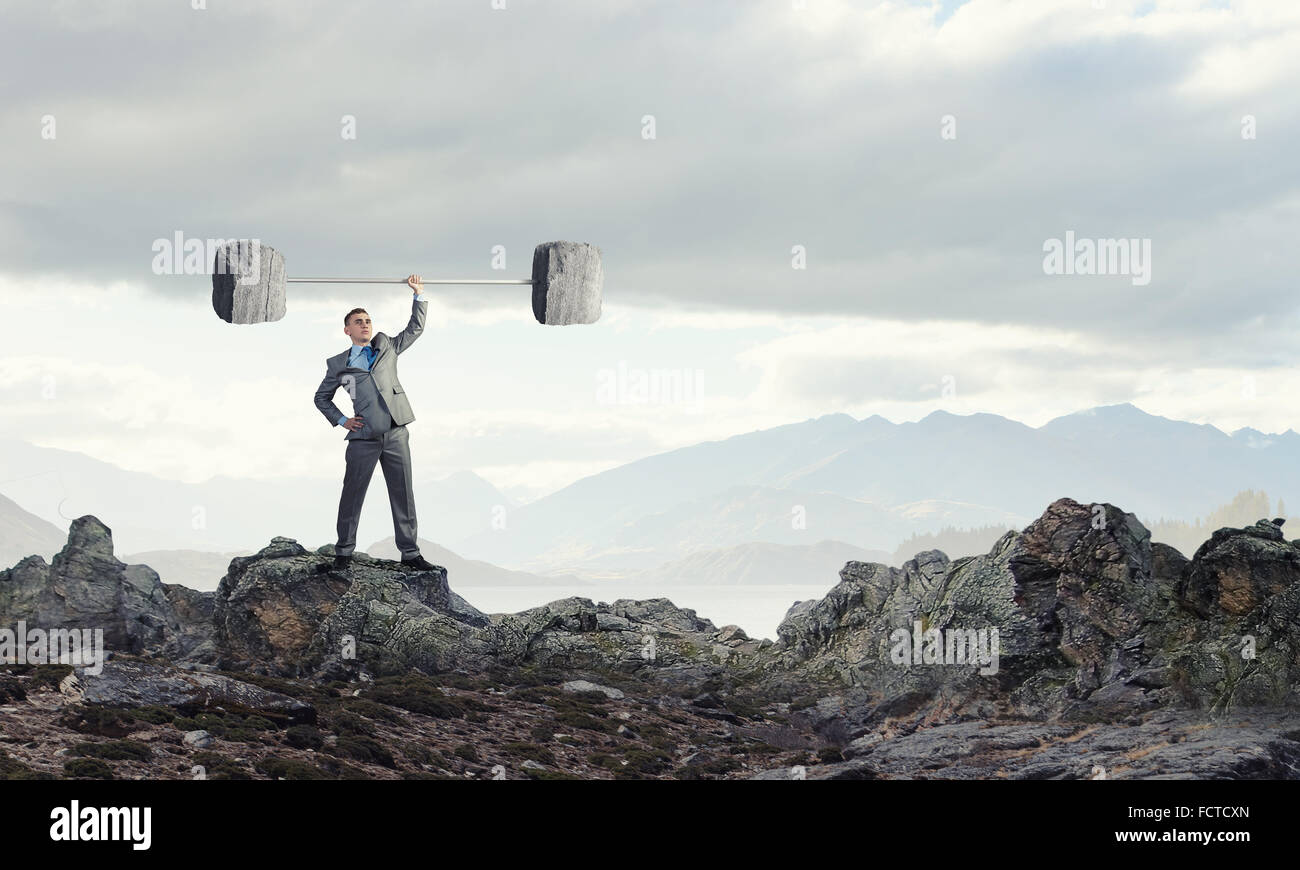 Confident businessman lifting above head stone barbell Stock Photo - Alamy