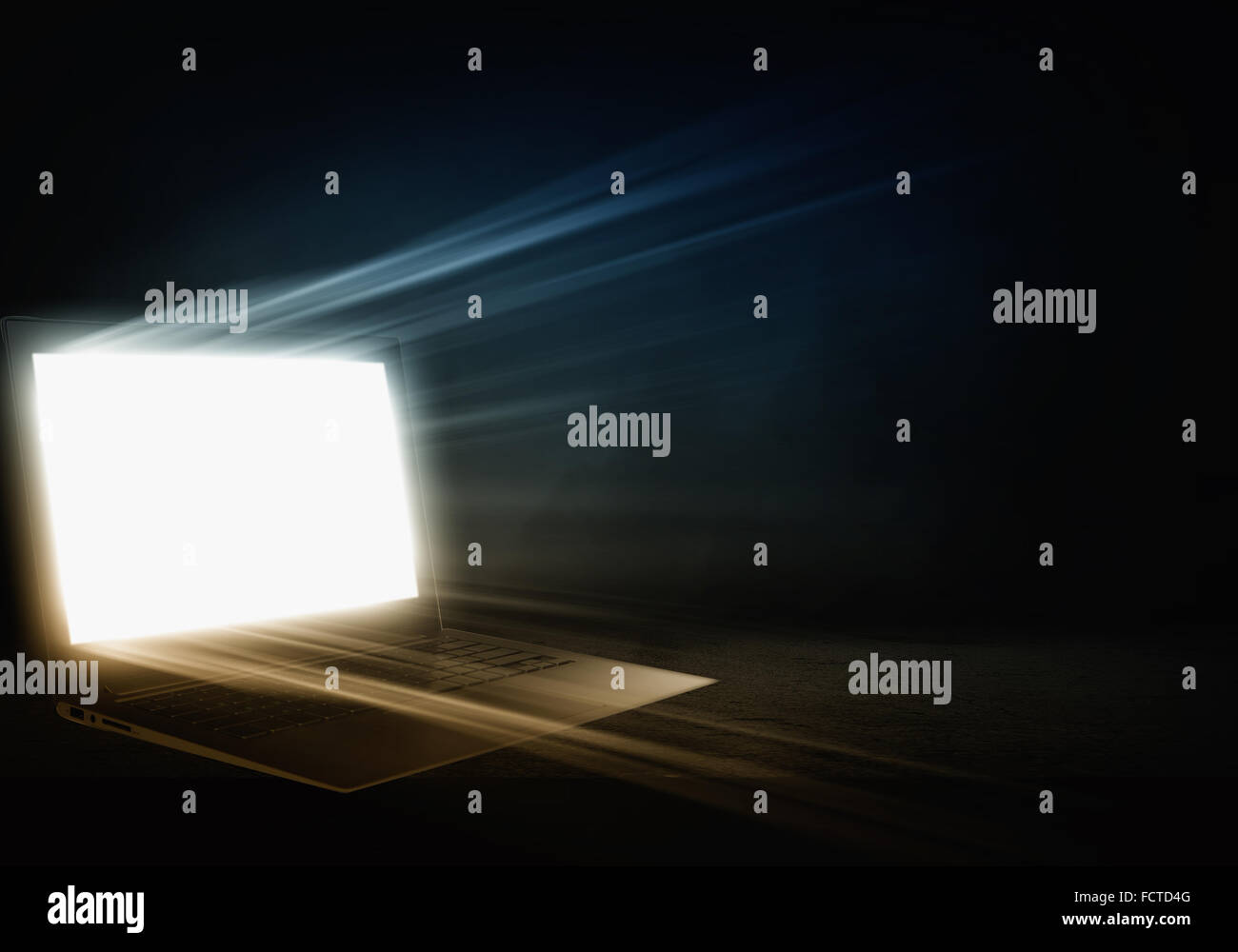 Open laptop with light coming from screen on dark background Stock ...