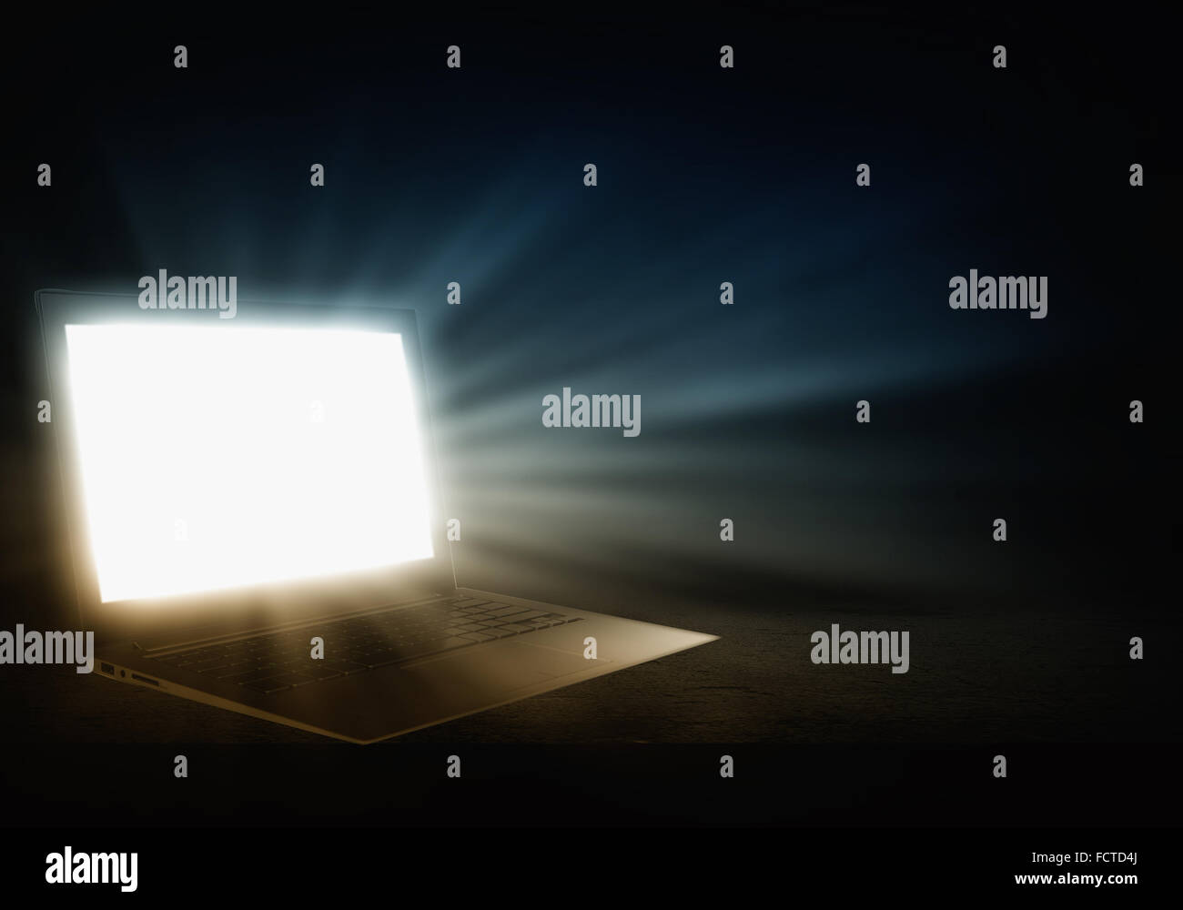 Open laptop with light coming from screen on dark background Stock ...