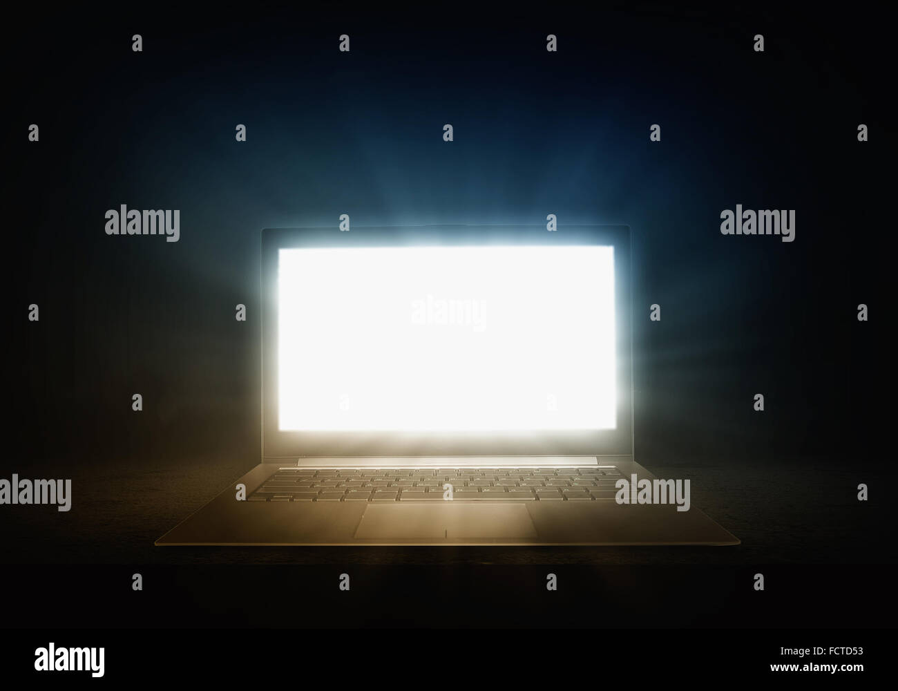 Open laptop with light coming from screen on dark background Stock ...