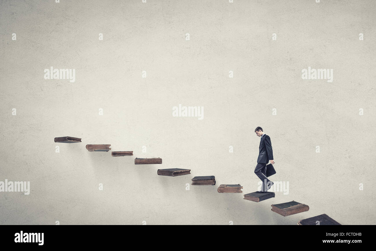 Young businessman walking up staircase representing success concept ...