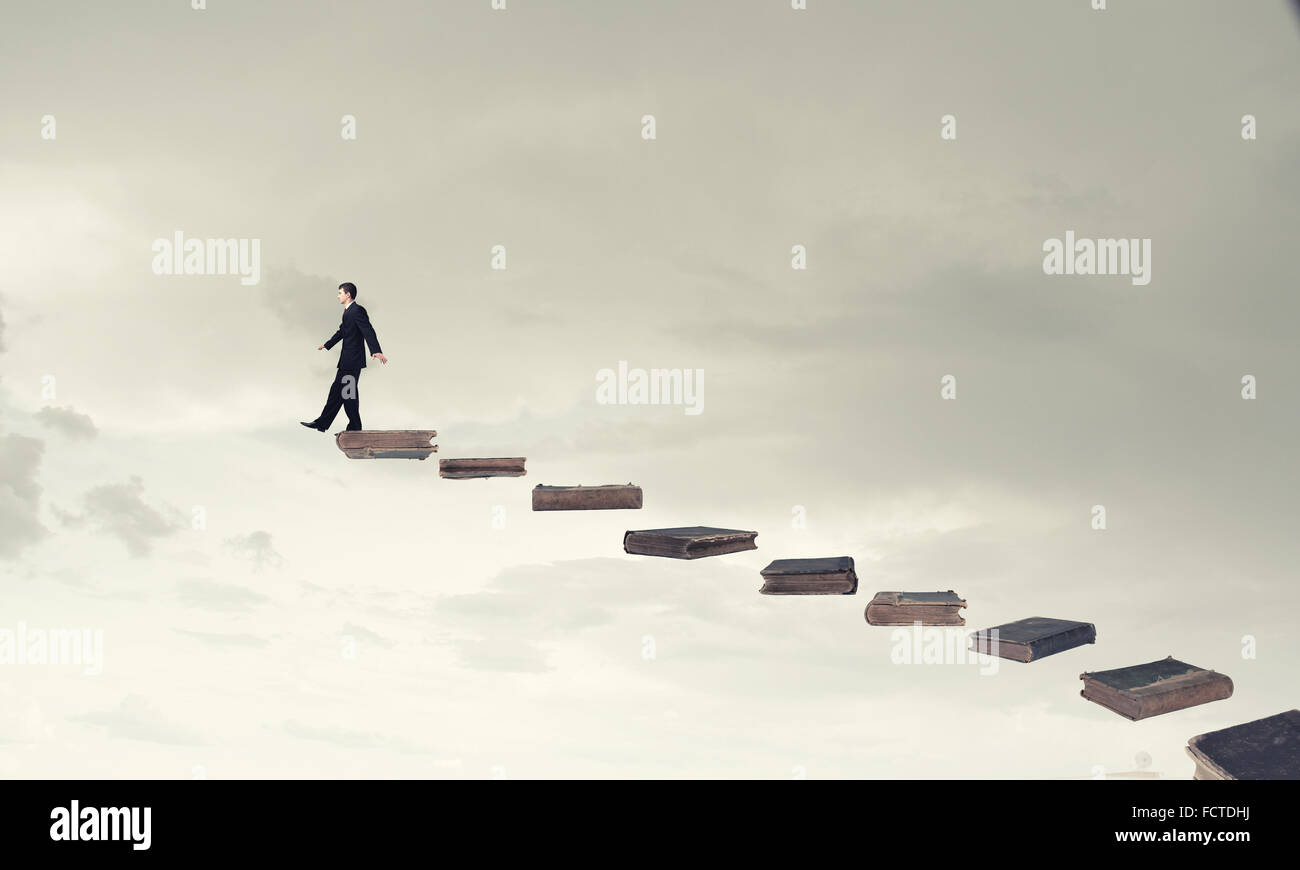 Young businessman walking up staircase representing success concept ...