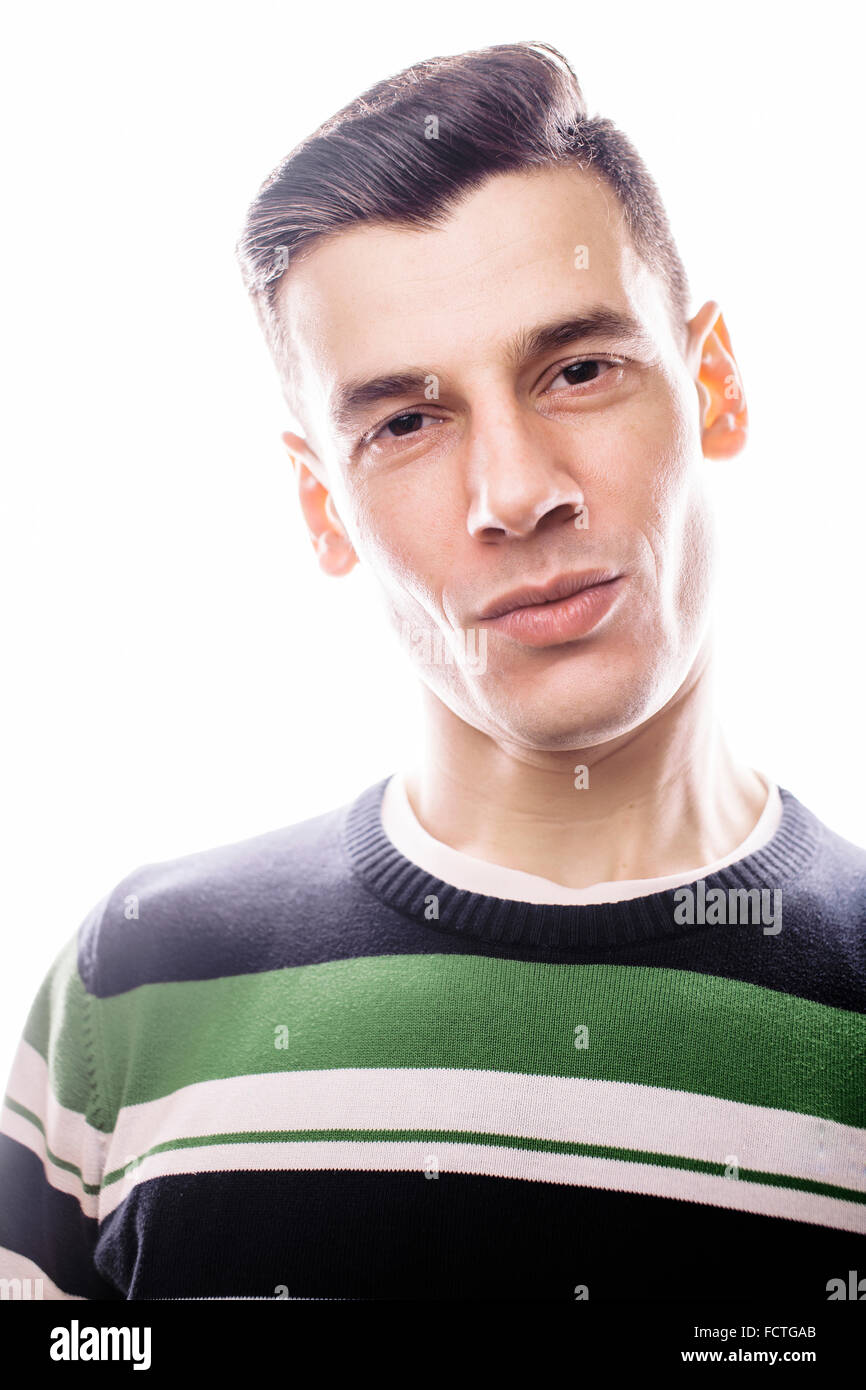 Portrait of a smart serious young man standing against white background ...