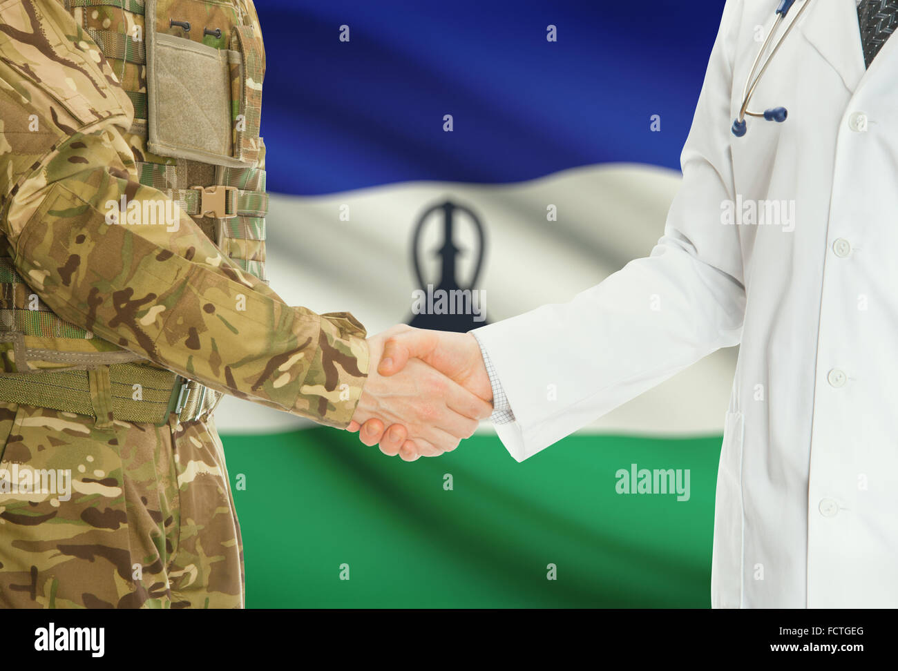 Soldier in uniform and doctor shaking hands with national flag on ...