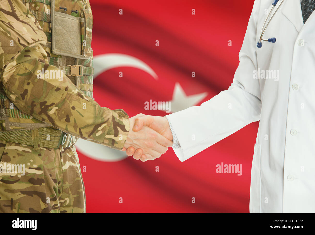 Soldier in uniform and doctor shaking hands with national flag on ...
